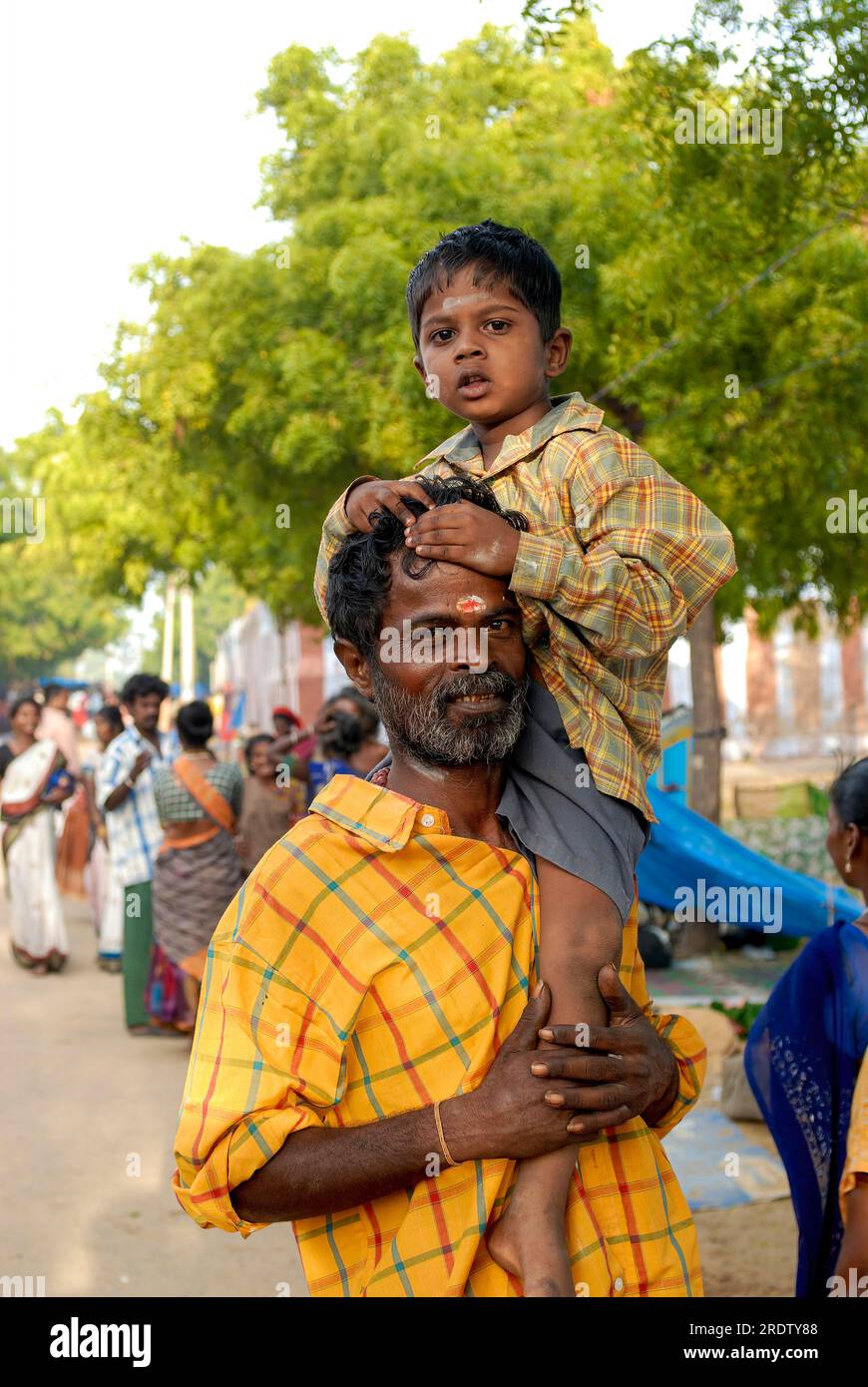 Narikuravar is an indigenous community man carrying his son on the ...