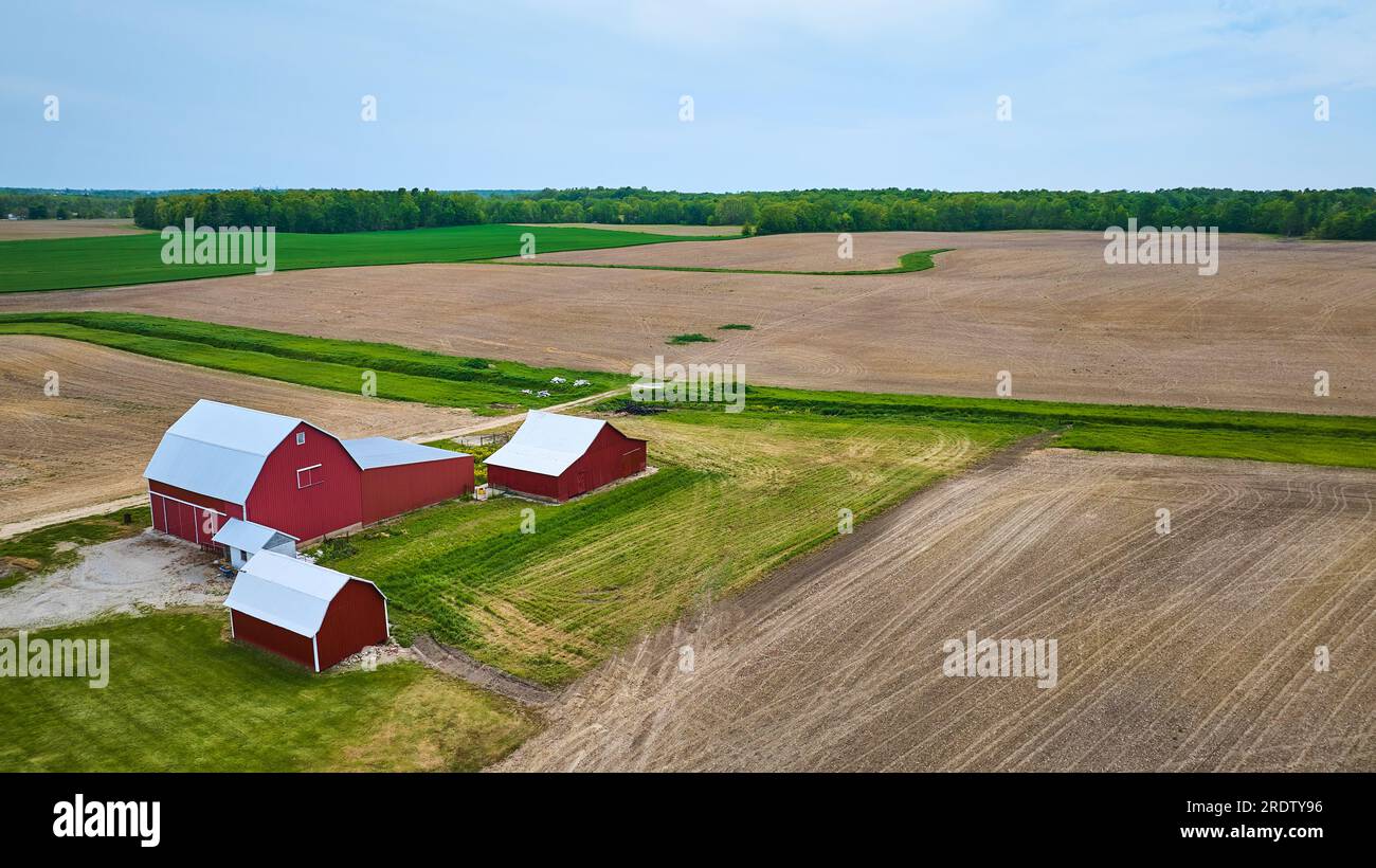 Red barn, shed buildings on farm property tilled plowed empty fields ...