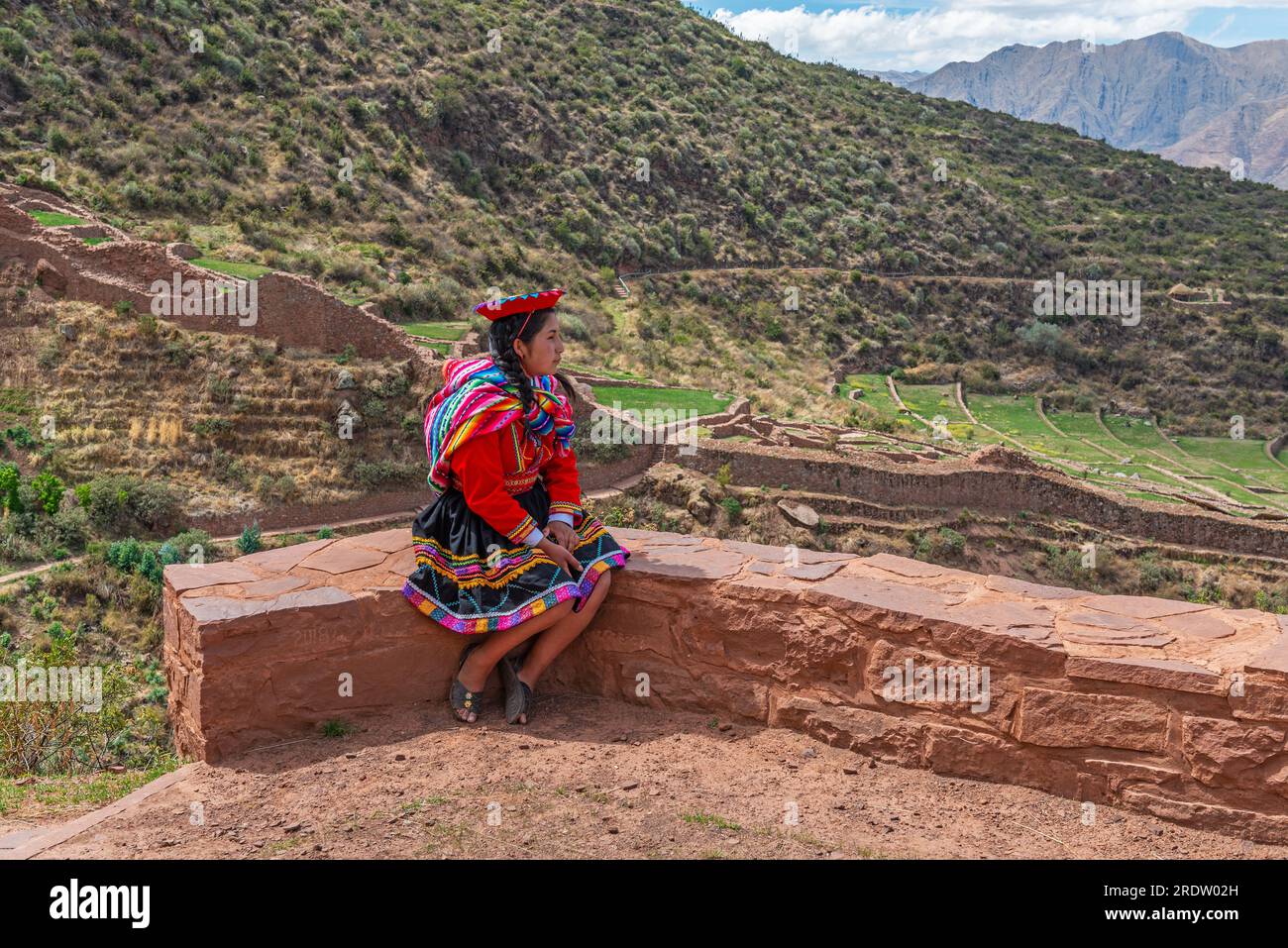 Peruvian Quechua indigenous lady on Inca wall in traditional clothing ...