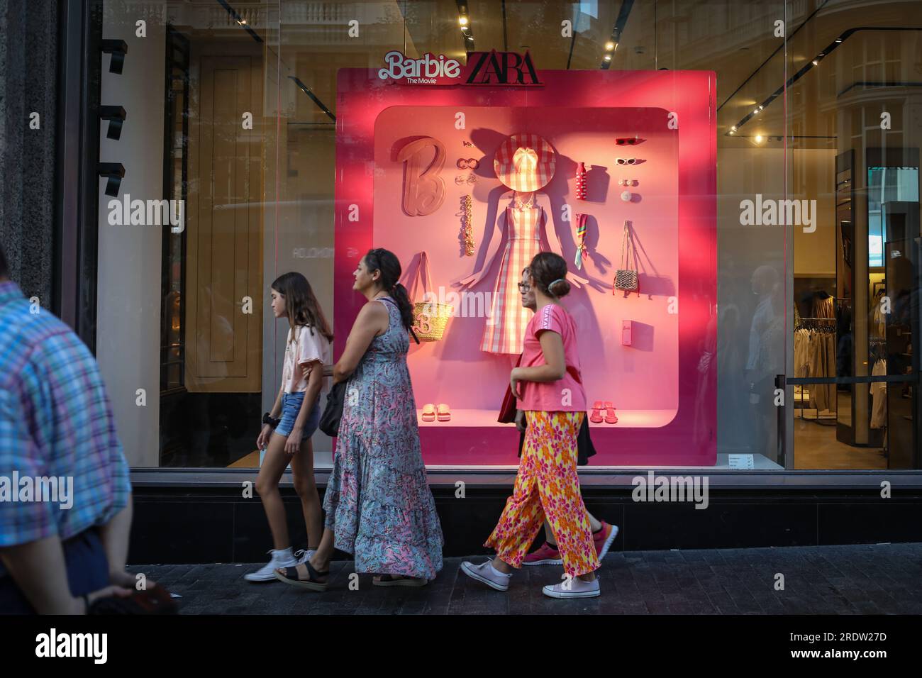 People walk outside the window of the Zara store on Madrid's Gran Vía ...