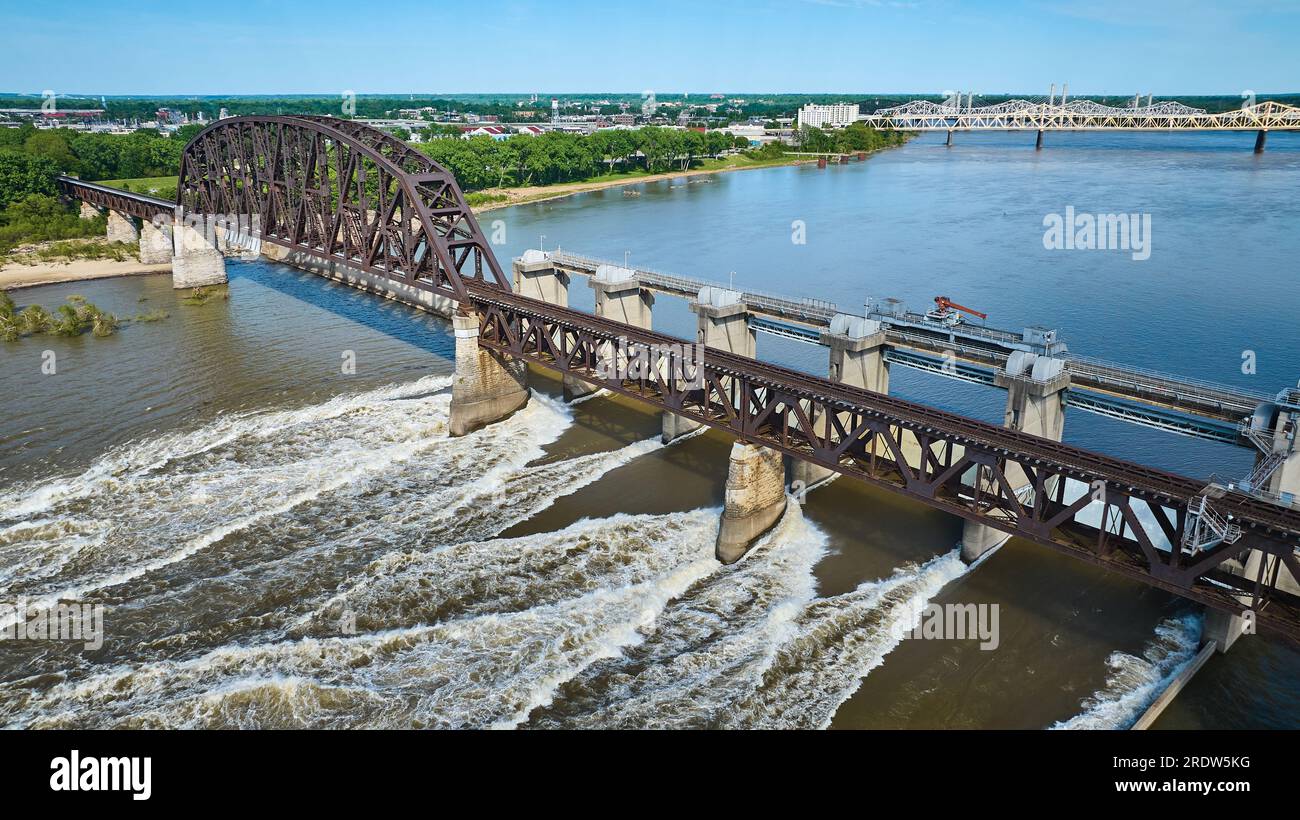 Truss arch bridge over large dam blue river water and white water ...
