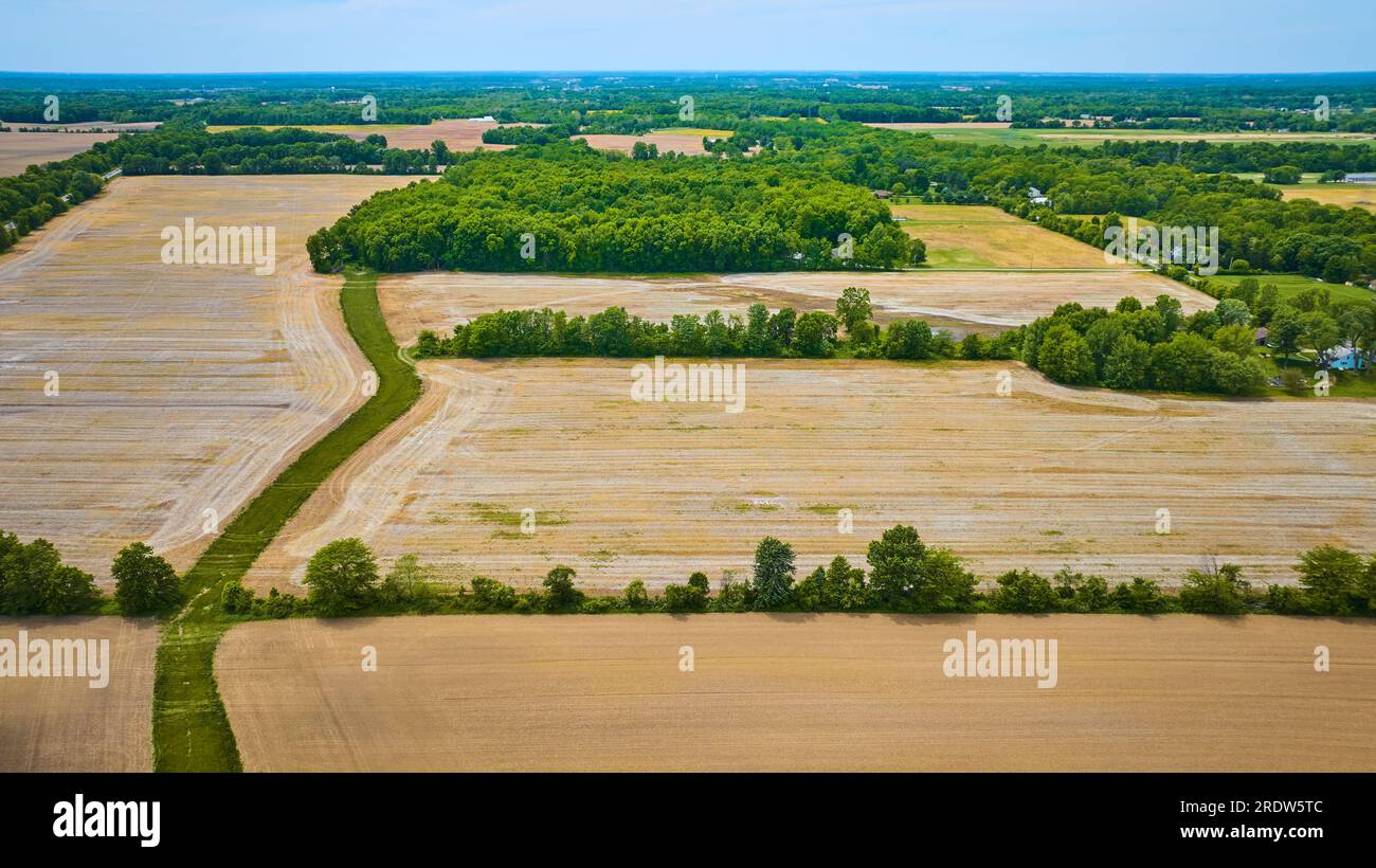 Aerial of green path snaking its way through empty farmland on way to ...