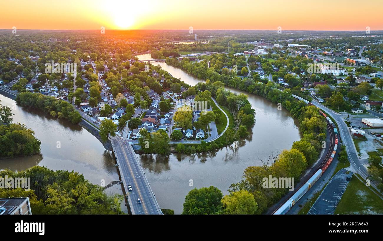 Aerial horseshoe riverbend train and small cityscape landscape village ...