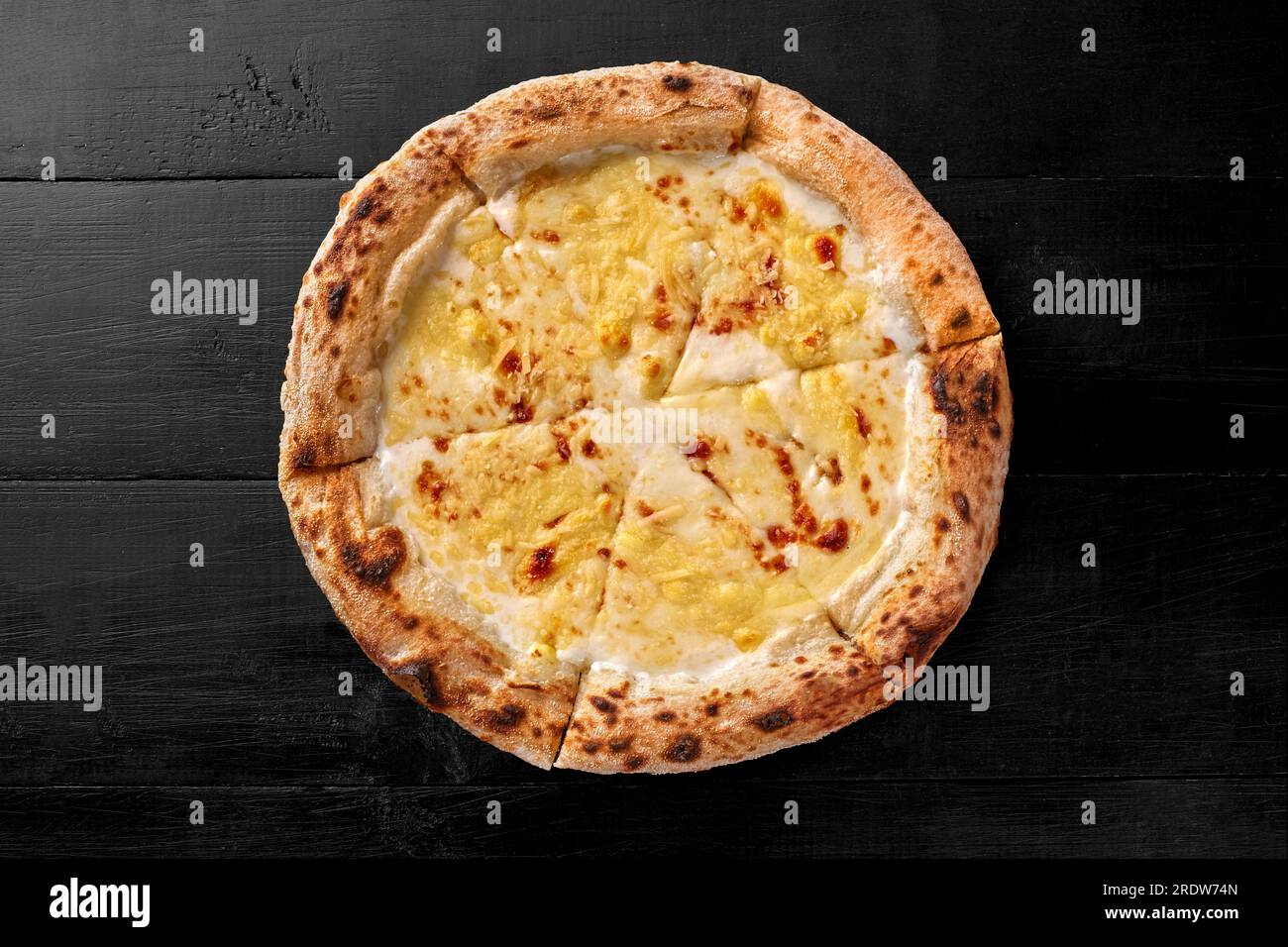 Cheese pizza with browned edge on black wooden background Stock Photo ...