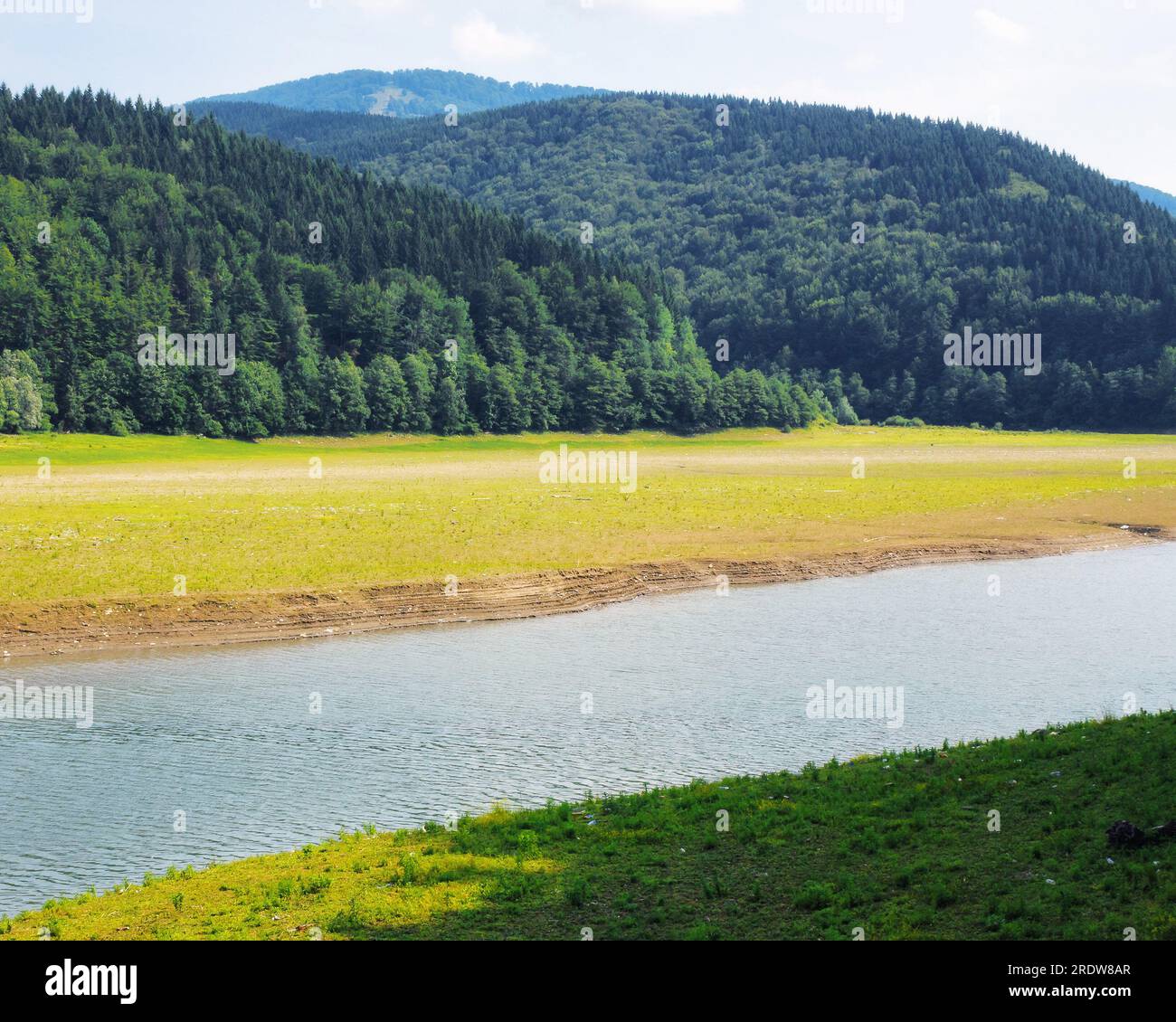 scenery with river in valley. shores polluted with plastic and garbage ...