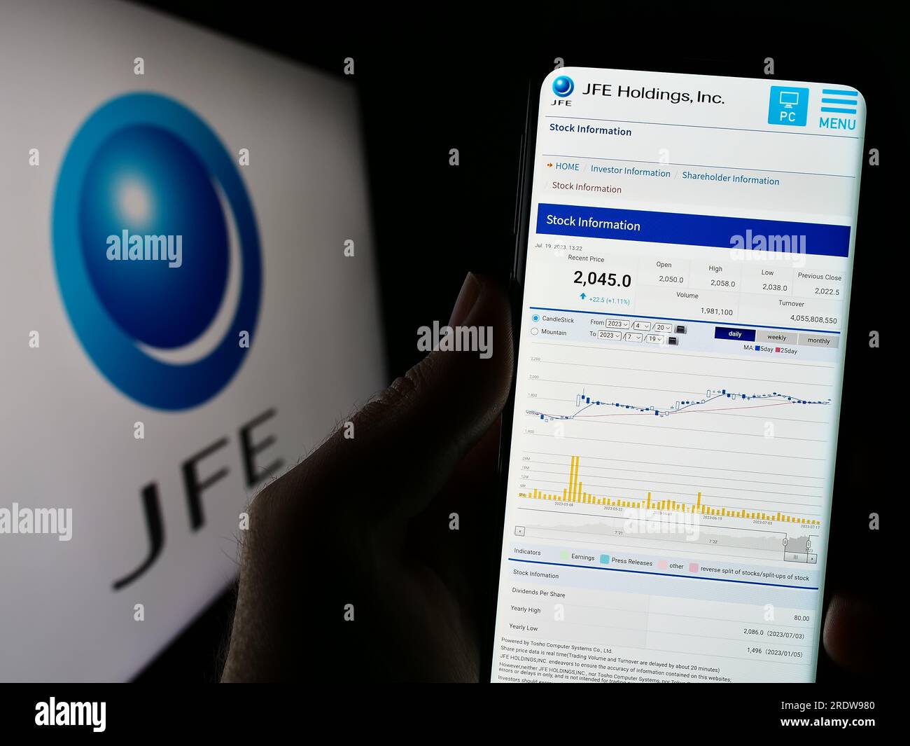 Person holding cellphone with website of Japanese steel company JFE Holdings Inc. on screen in ...