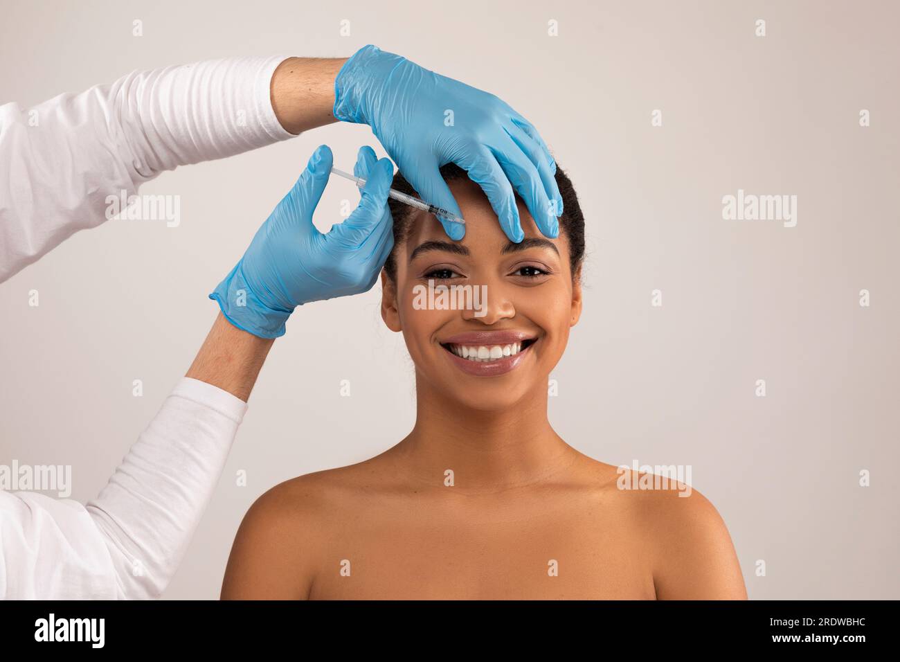 Young black woman getting beauty cosmetic injection in forehead Stock ...