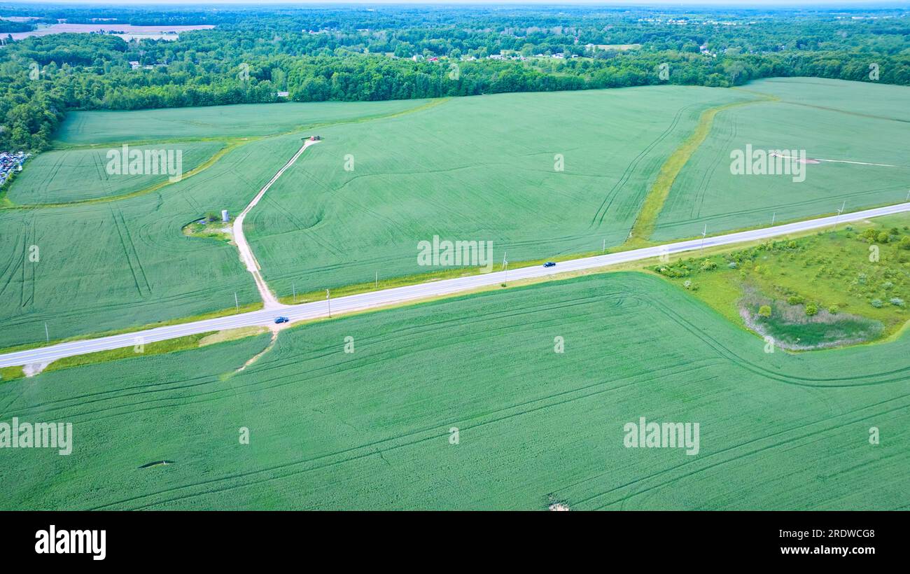 Aerial large farmland with green crops and country road with cars Stock ...