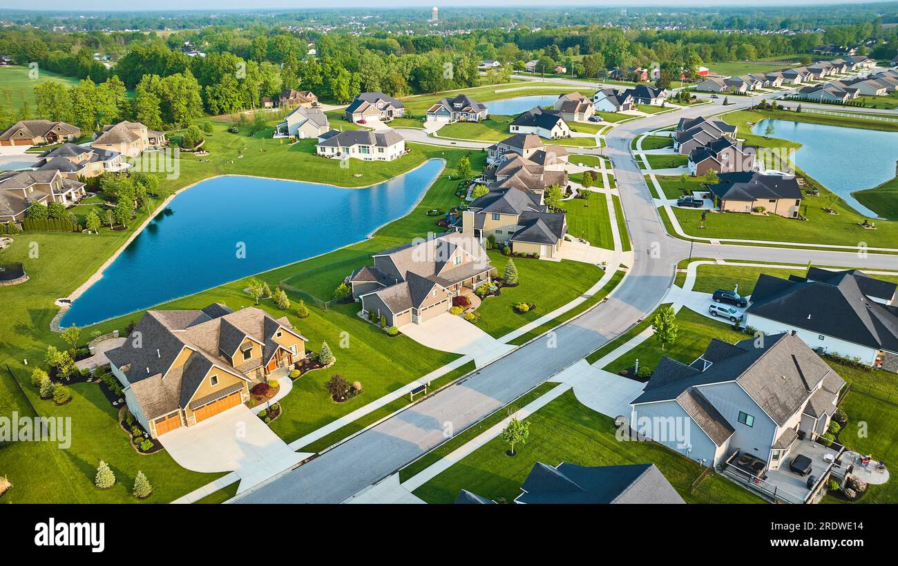 Aerial large ponds in rich expensive neighborhood with mini mansions ...
