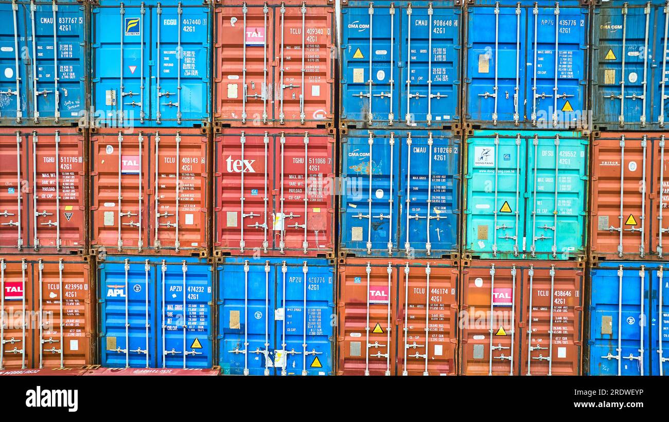 Ends of metal shipping crates containers stacked in colorful pastel ...