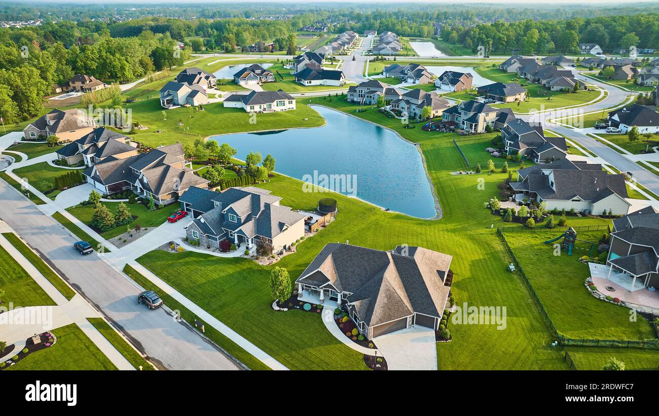 Large pond in rich expensive neighborhood aerial with mini mansions ...