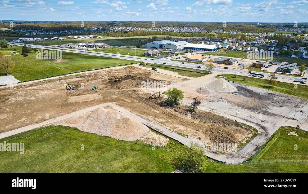 Construction muddy ground digger gravel pile aerial solar panels houses ...