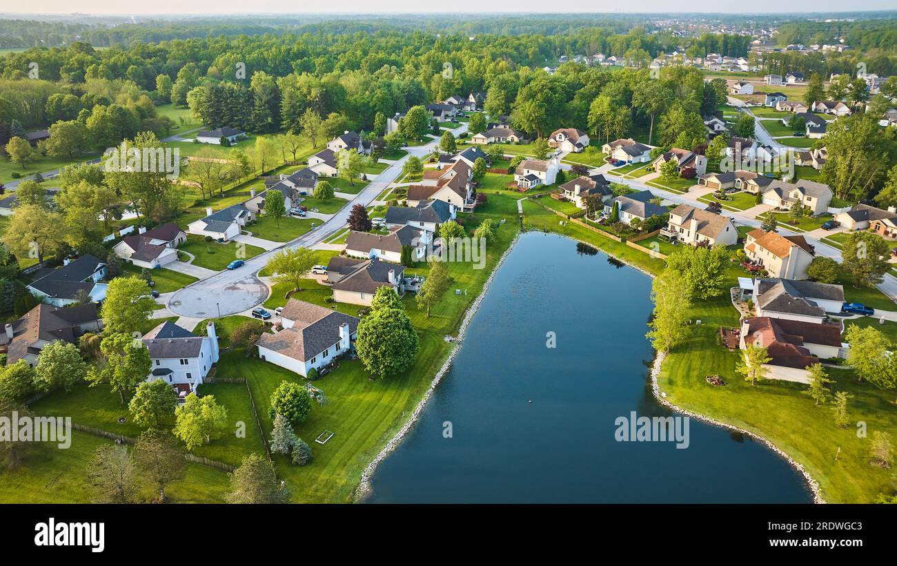 Dark blue pond with housing neighborhood and cul-de-sac suburban homes ...
