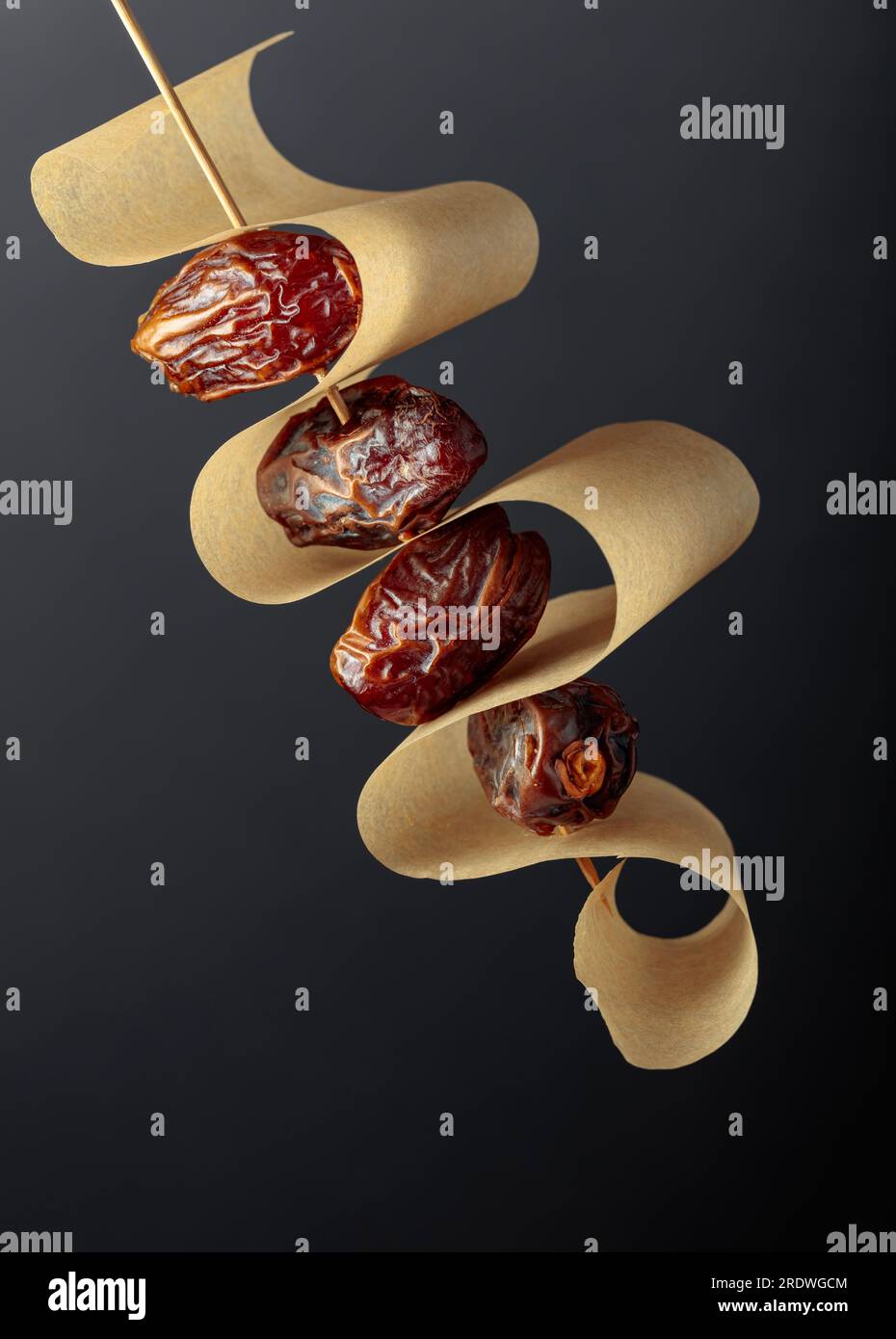Dried Arabic dates on a black background Stock Photo - Alamy