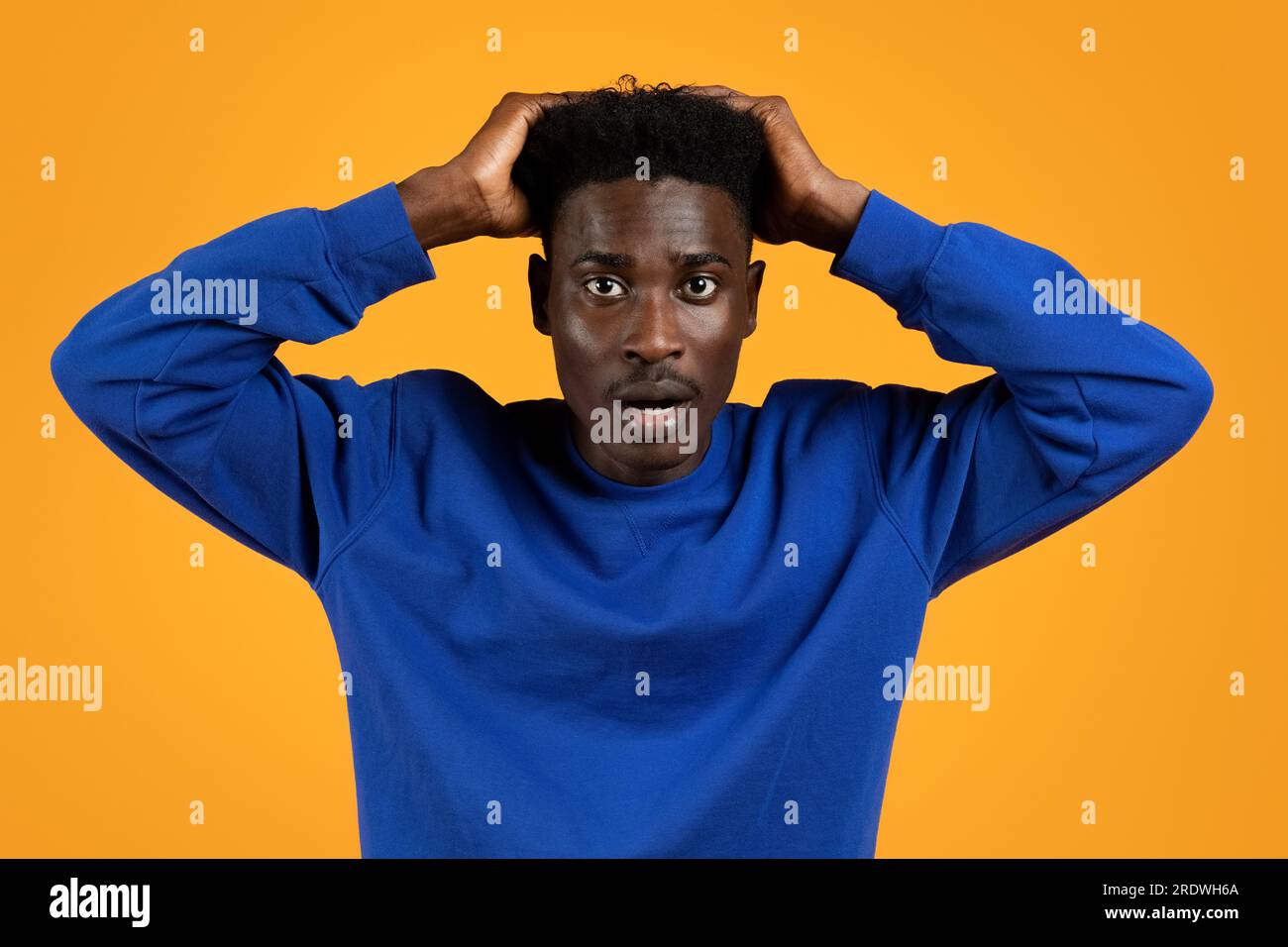 Shocked young black guy touching his head Stock Photo - Alamy