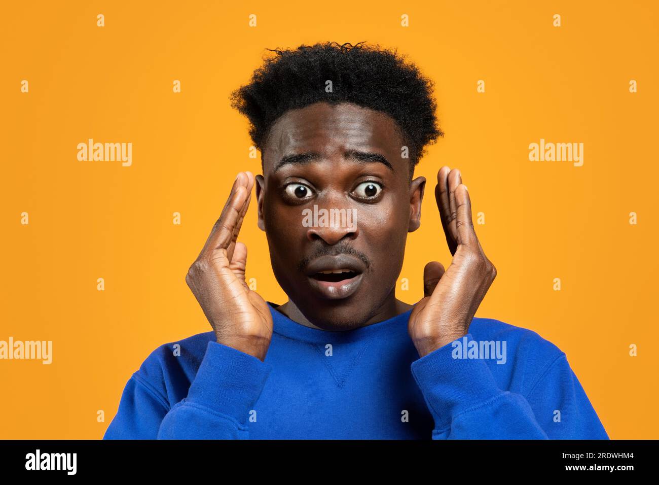 Shocked millennial african guy looking aside, yellow background Stock ...