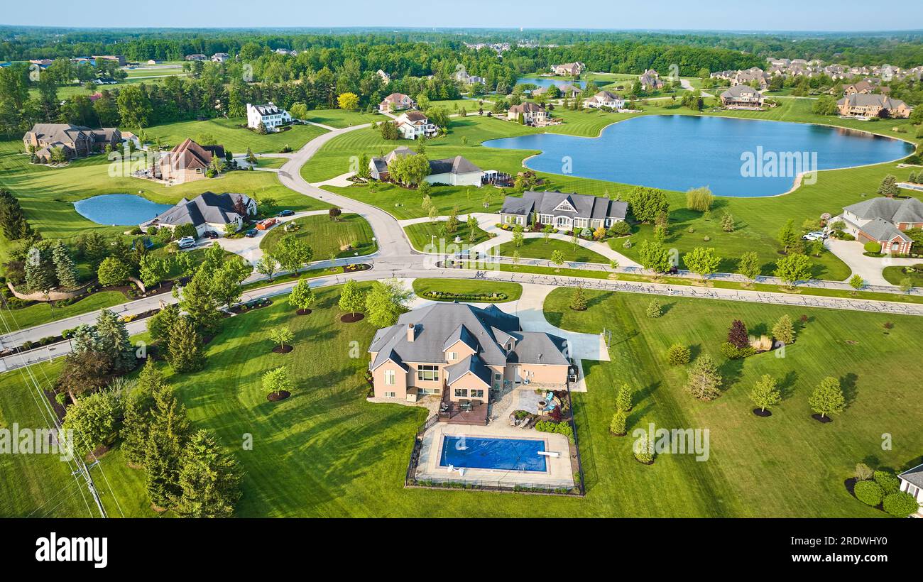 Aerial pond side properties rich expensive neighborhood fresh cut lawns ...