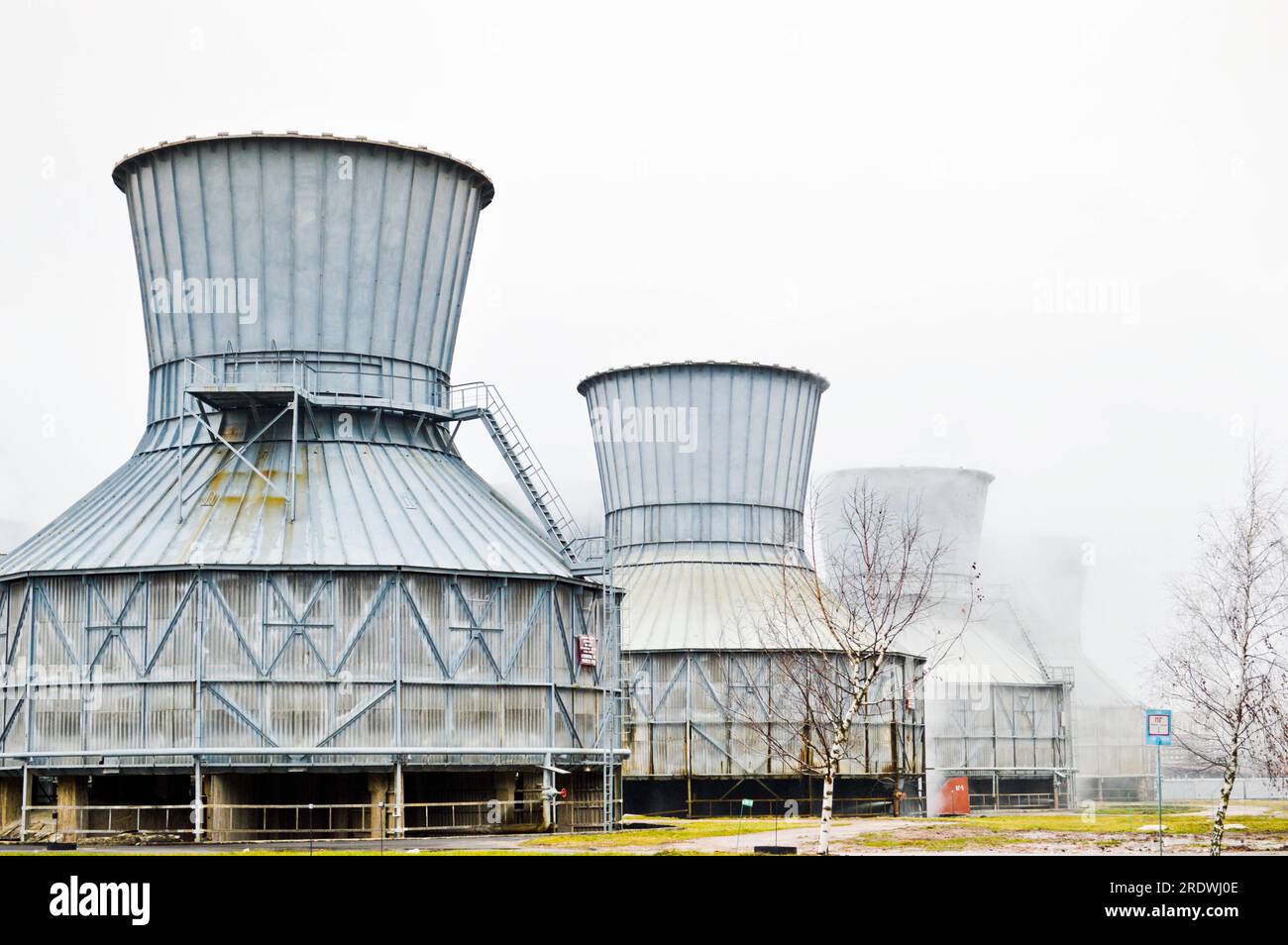 Large cooling towers in water and fog at an oil refinery, petrochemical ...