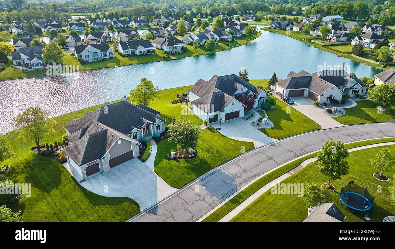 Large houses next to pond view and trampoline neighborhood aerial Stock ...