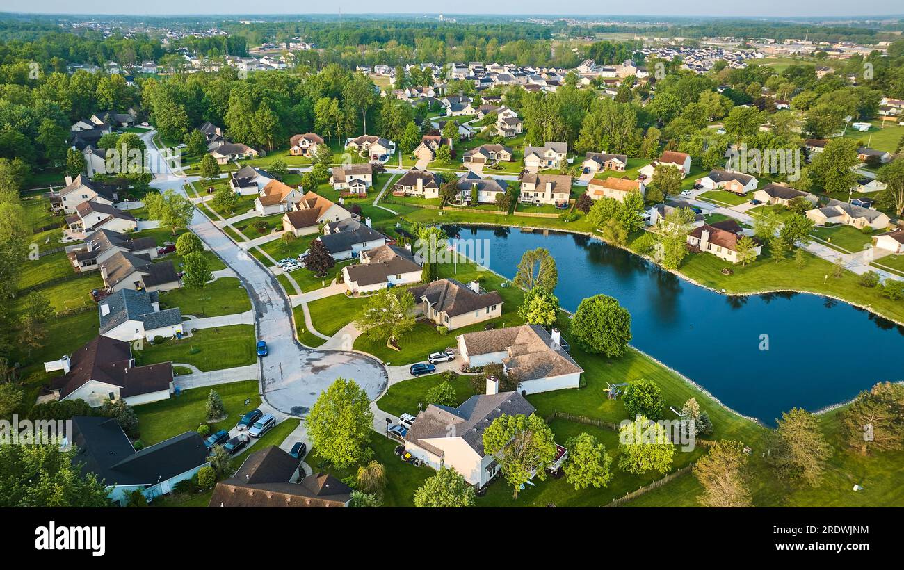 Dark blue pond with cul-de-sac and housing neighborhood suburban homes ...