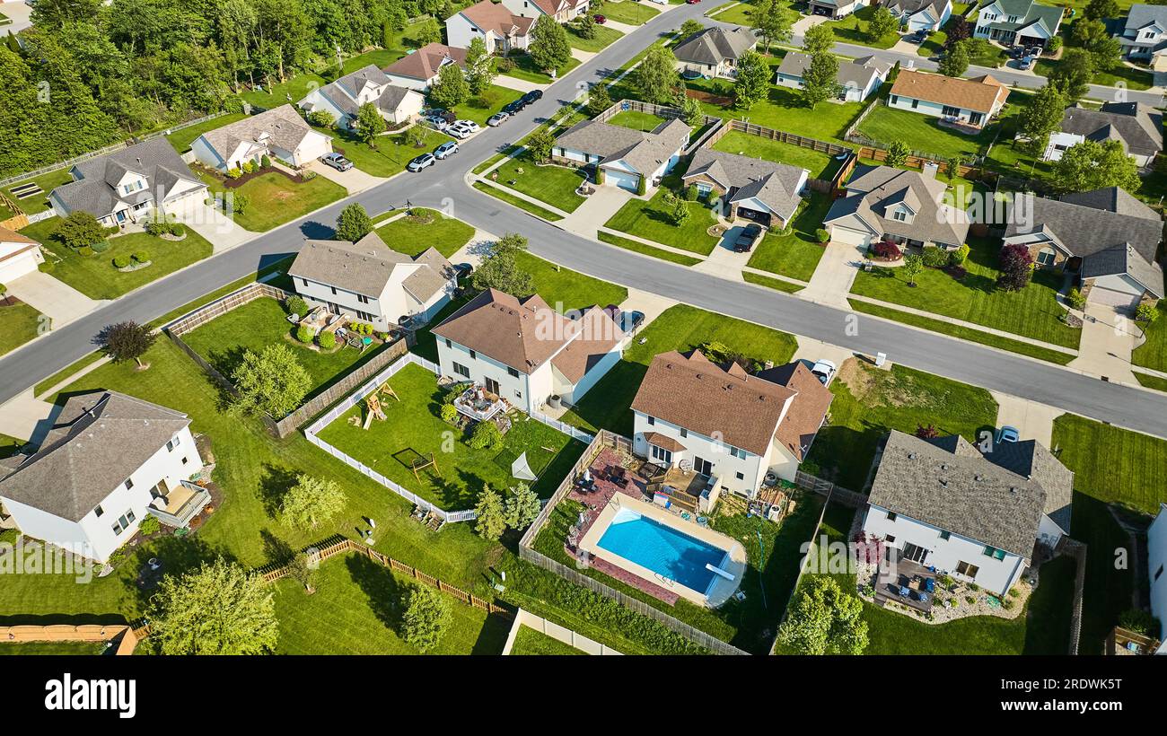 Aerial over multiple two story houses in neighborhood a pool in ...
