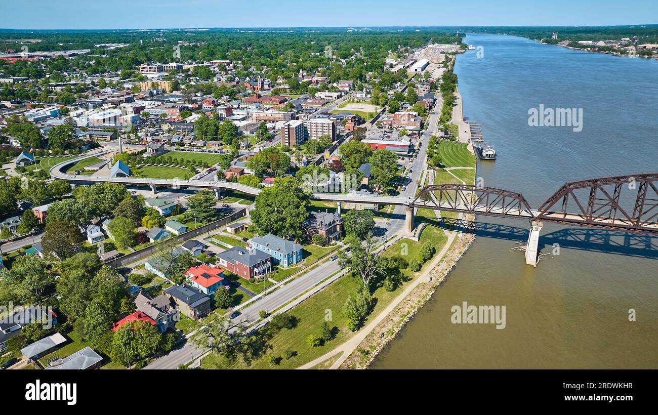 Aerial iron arch bridge over long Ohio River water with city town ...