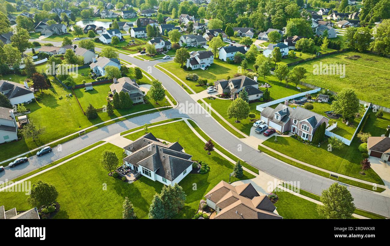 Aerial suburban neighborhood fresh cut green lawns middleclass housing ...