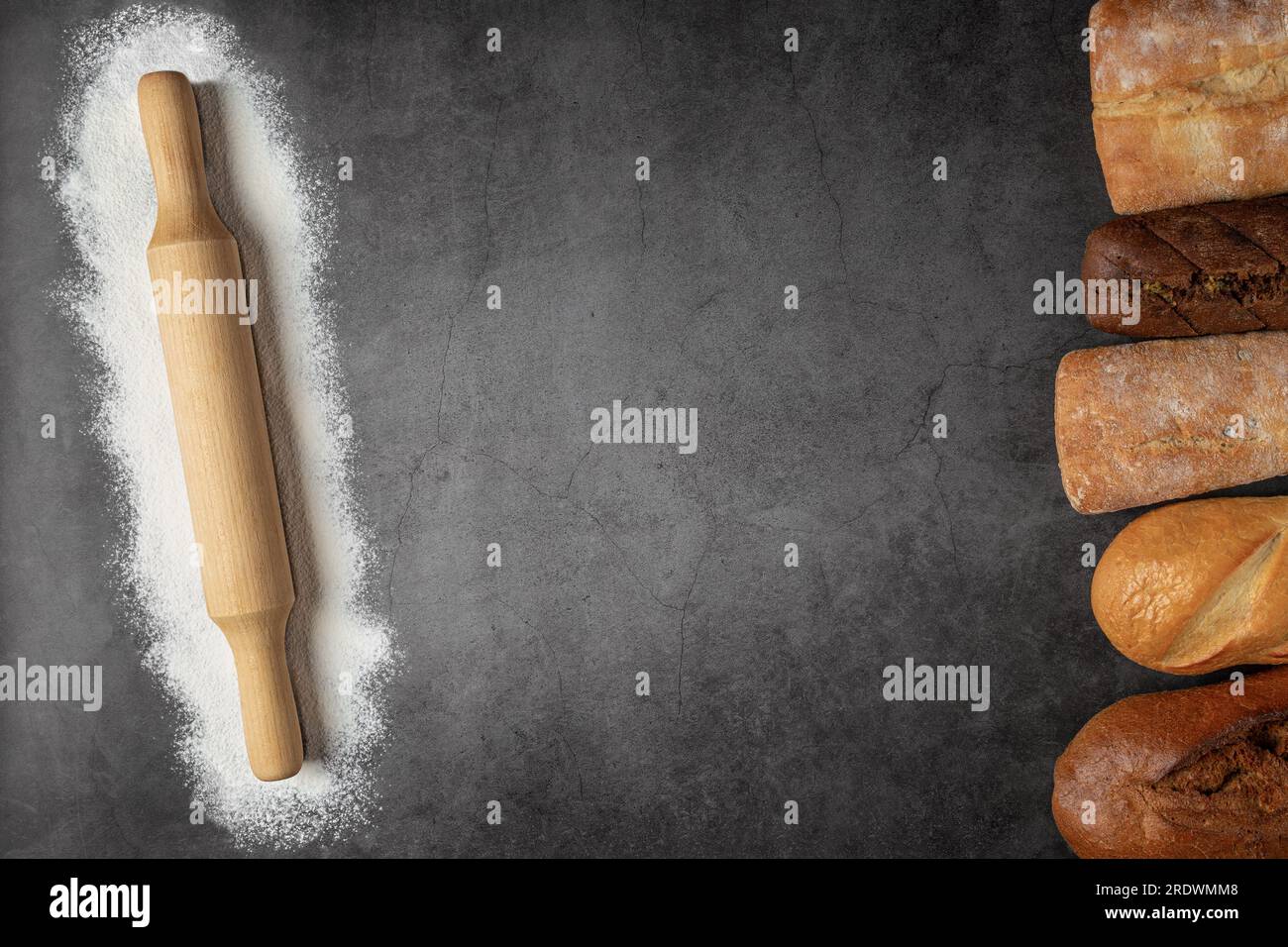 Baking dark background with copy space with various fresh baked bread ...