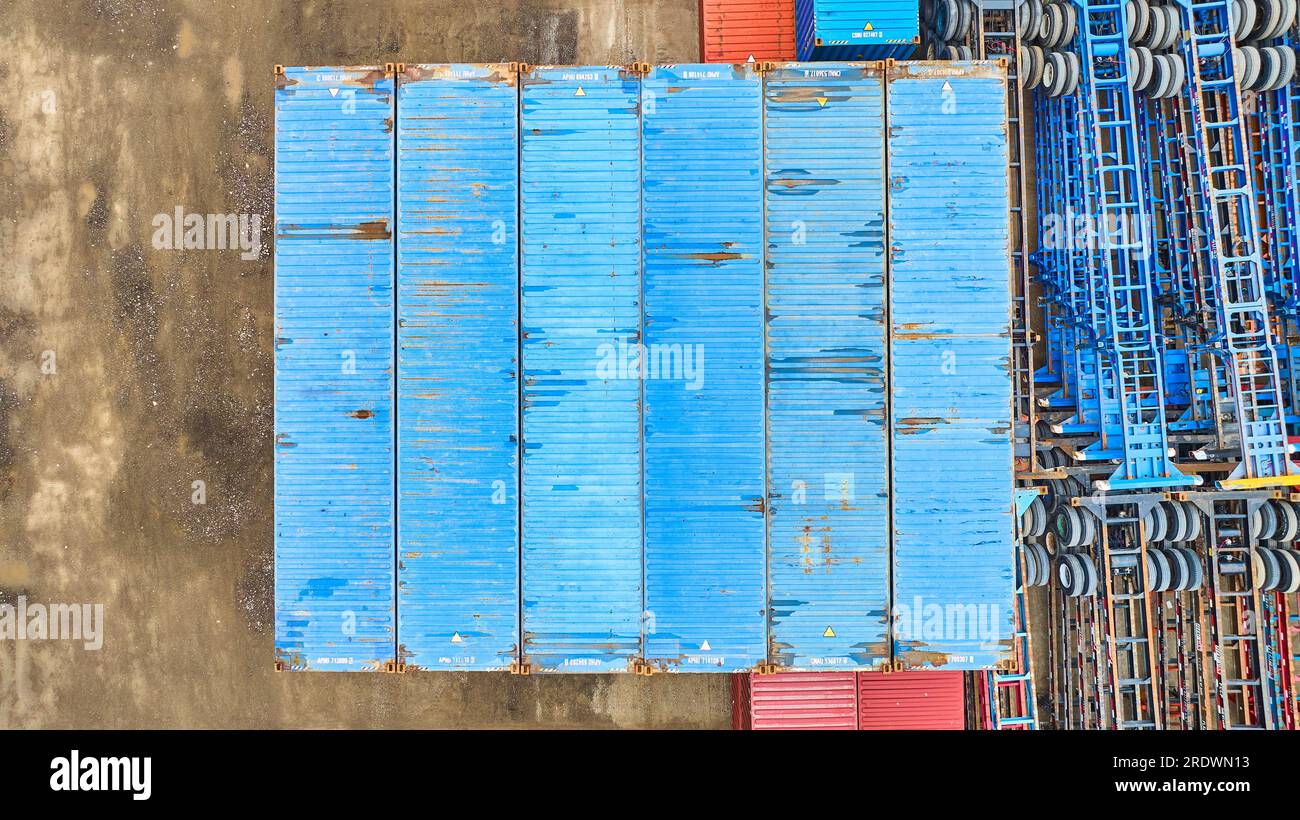 Moving belt at shipping container port, large blue metal containers ...