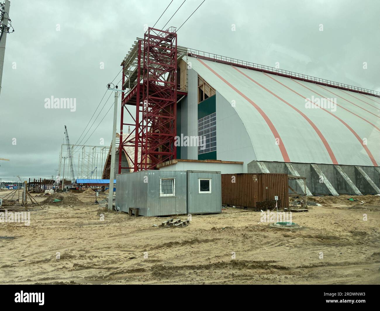 A large industrial barn warehouse and modular buildings for workers at ...