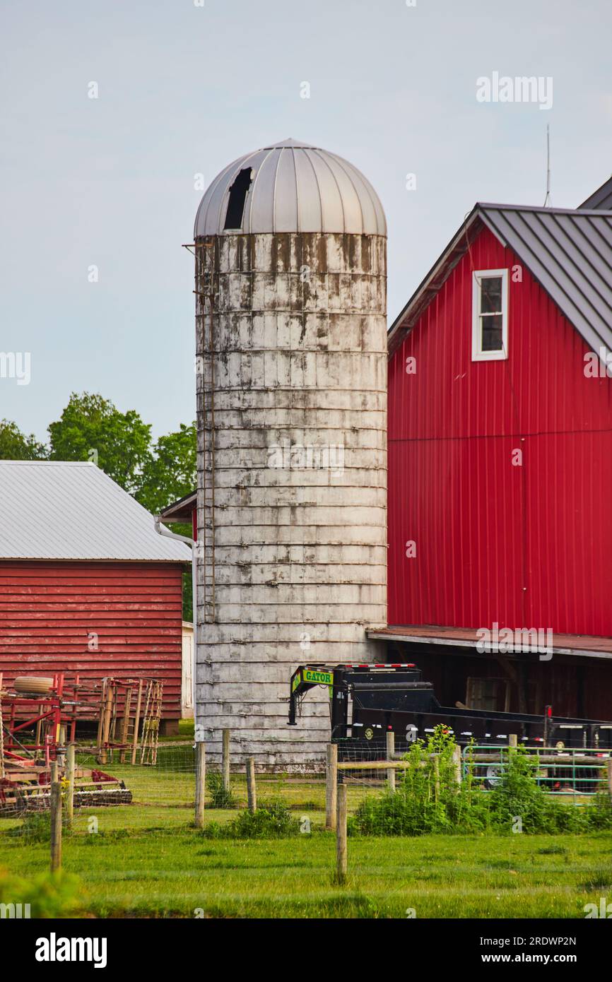 Vertical of dirty white silo outside pristine red barn Stock Photo - Alamy