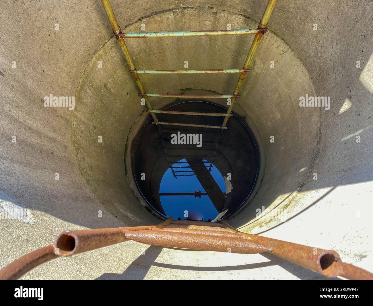 A large round deep well made of concrete rings with clean well ...