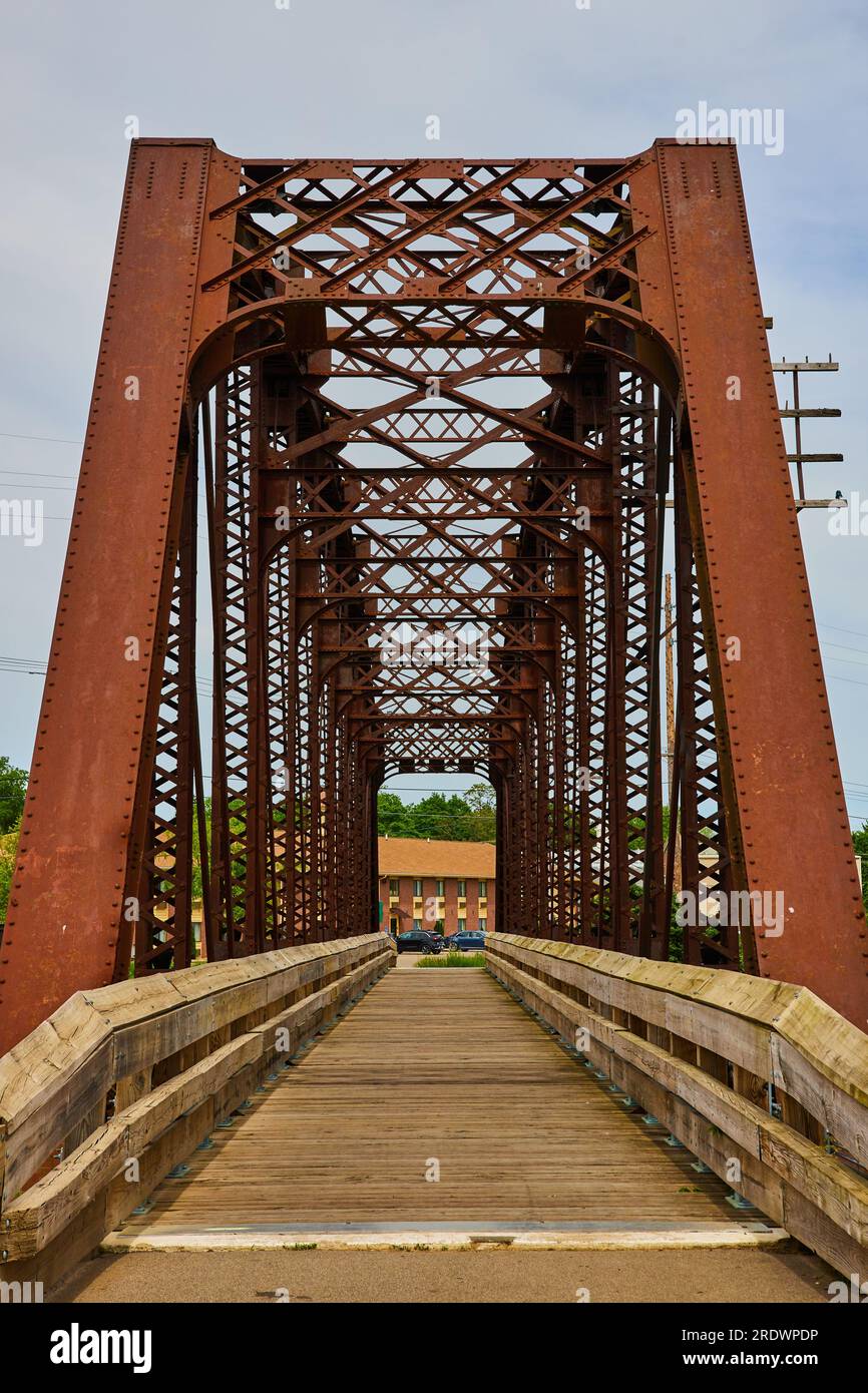 Vertical of metal iron bridge with wooden walking path in summer under ...