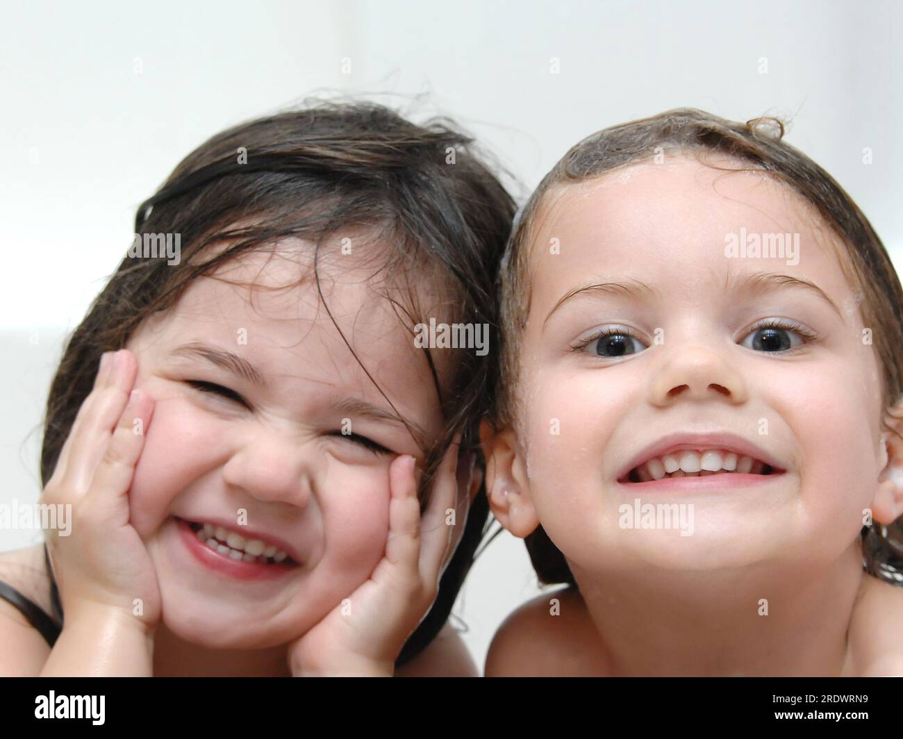 Two Sisters Laugh Through Bath Time With Wet Heads And Smiles Closeup Shows One Sister Smiling