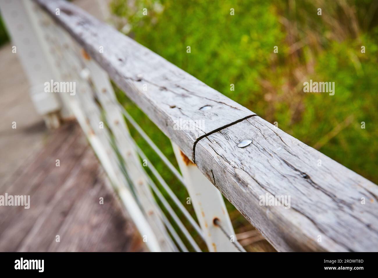 Weathered wooden railing atop rusty white railing macro close up with ...