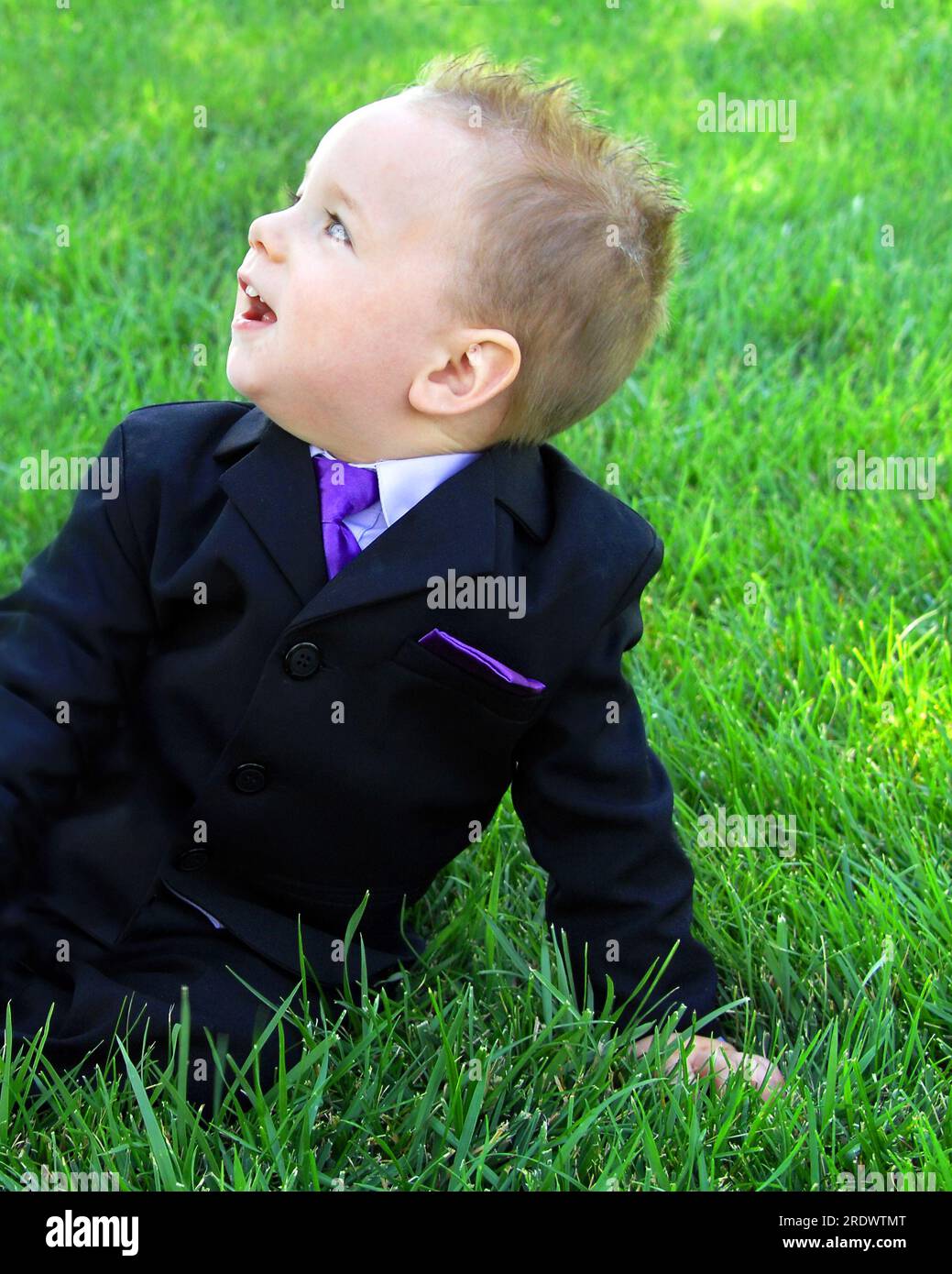 Little boy looks up in amazement and wonder. His mouth is open and he ...