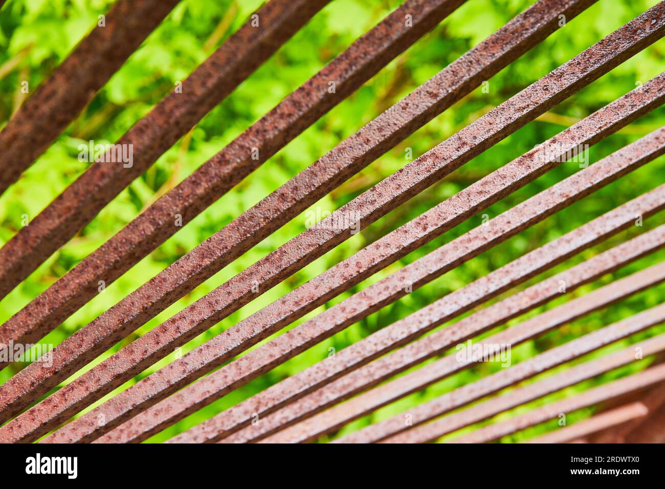 Bright sunlight reflecting silvery off red rusting metal bars with ...
