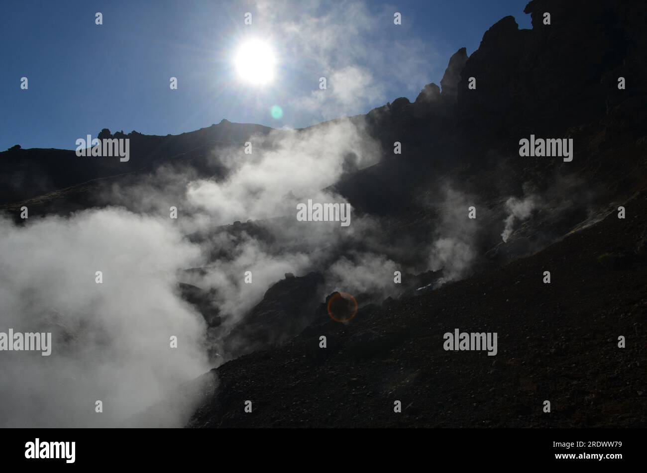 Steam rising from volcanic rock with the sun shining down Stock Photo ...