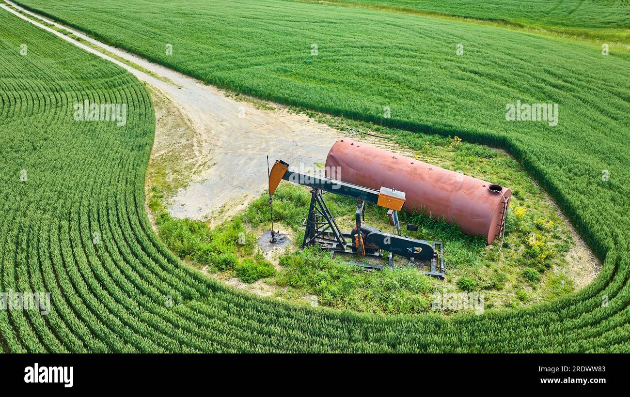 Oil pump jack and tank in field with maintenance road aerial Stock ...