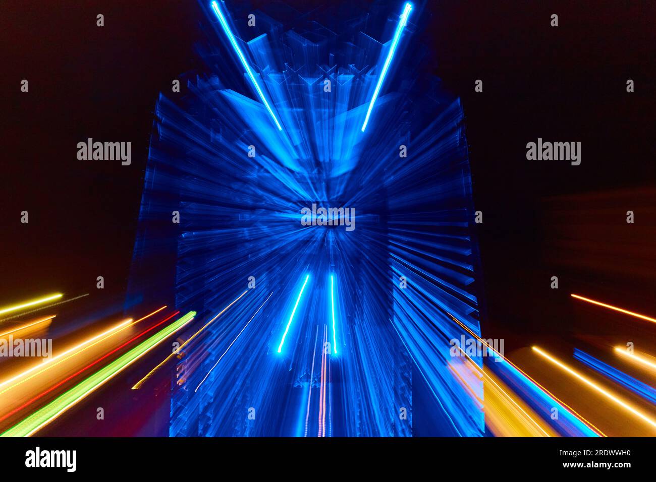 Blurred night shot of blue neon lights with blurry yellow and red city ...