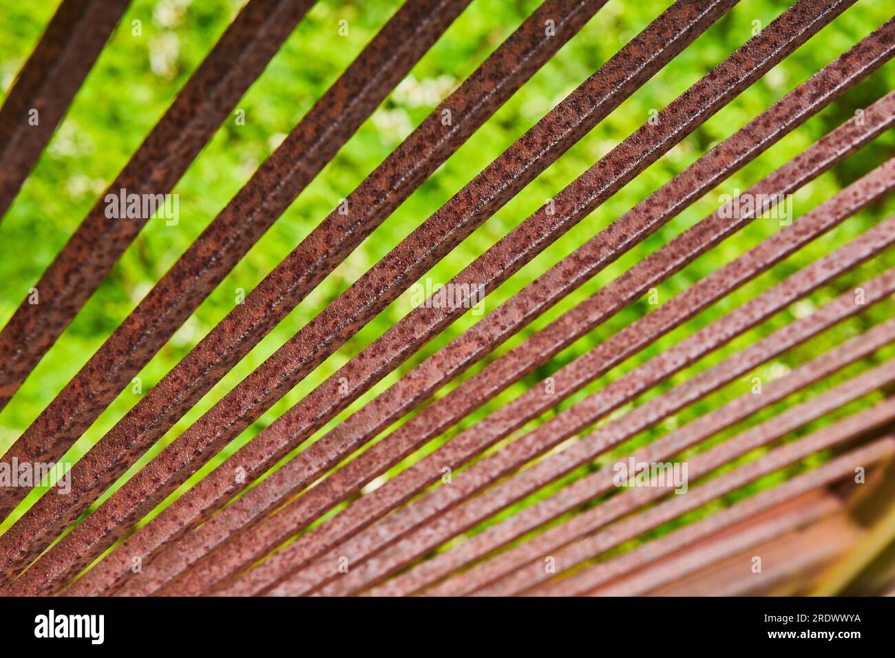 Close up fan formation of rusty red and dark brown metal spokes or ...