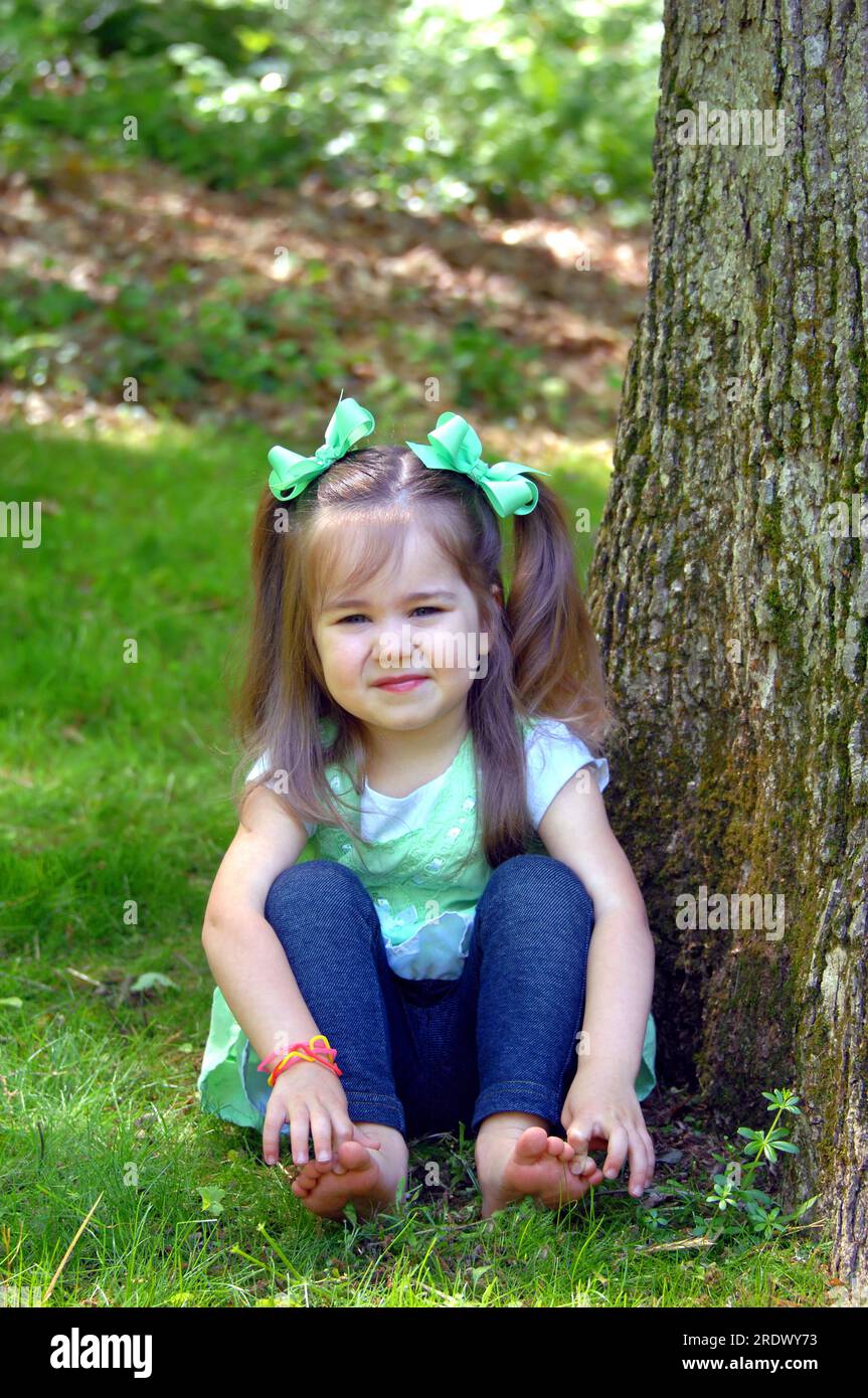 Beautiful little girl wiggles her toes as she enjoys going barefoot on ...