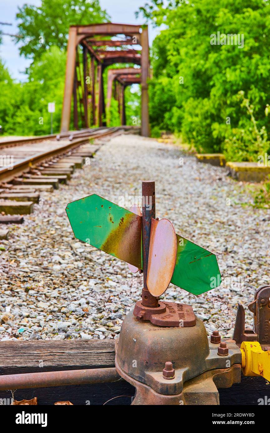 Rusty railroad switch with green paint and yellow lever on train tracks ...