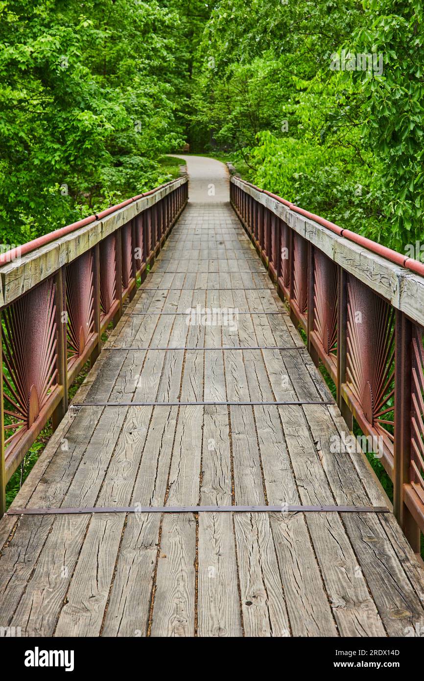 Boardwalk with rusty metal bar railing and worn wooden beams and planks ...