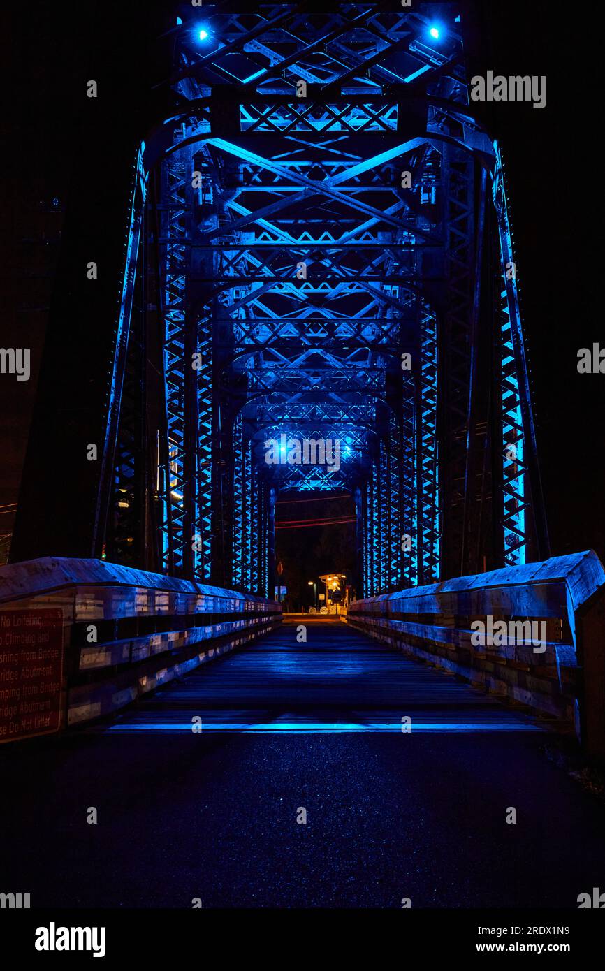 Walking bridge at night entrance to railroad bridge with neon blue ...