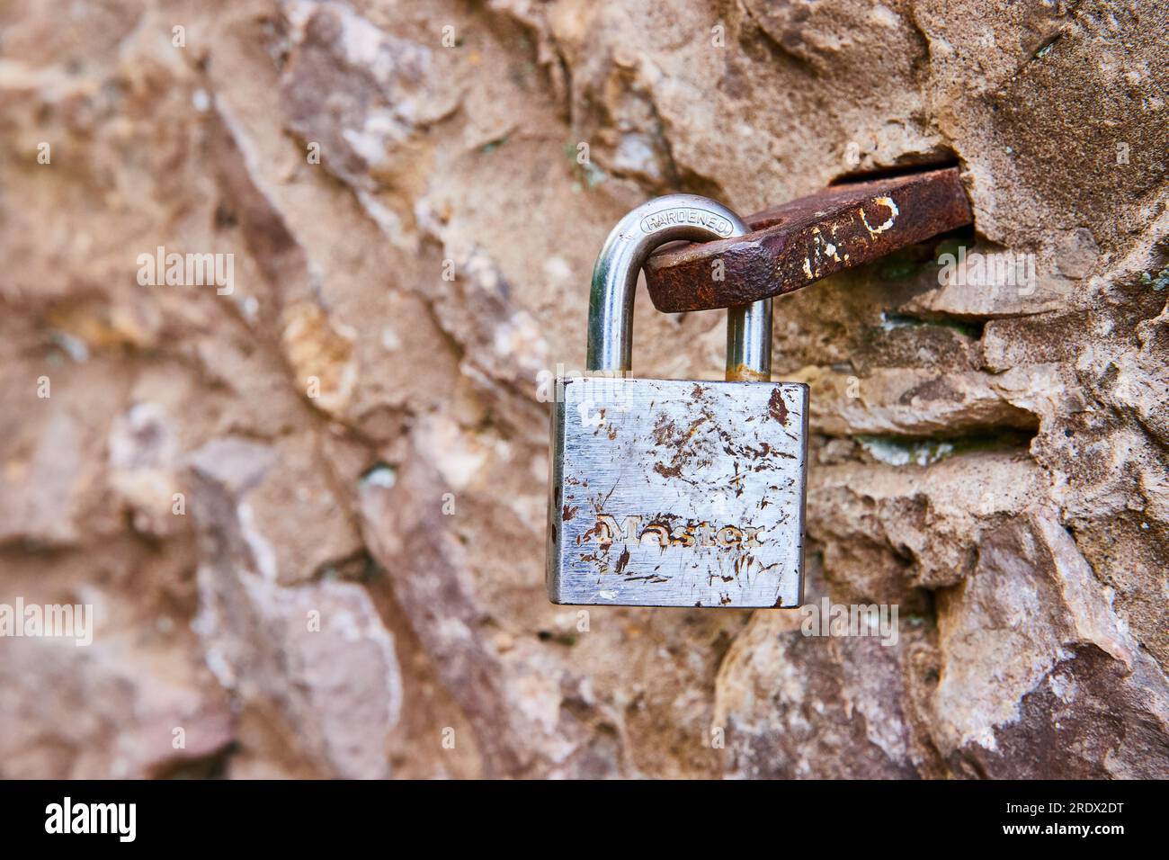 Clay rock wall, rusty metal loop, hook, rusting closed silver metal ...