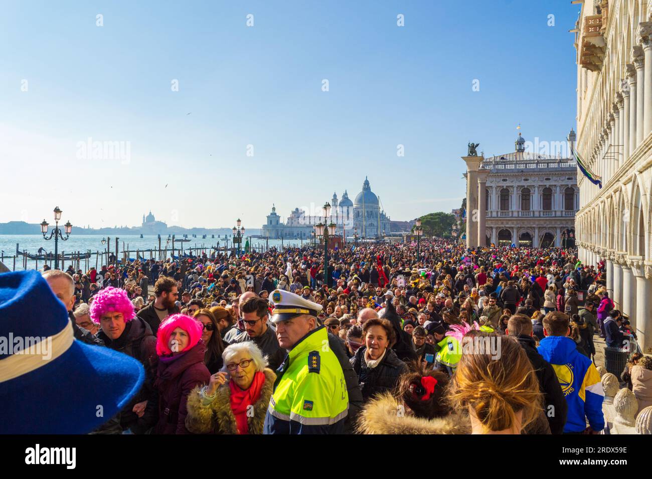 crowds of tourists and masquerade costumed people walking back and ...