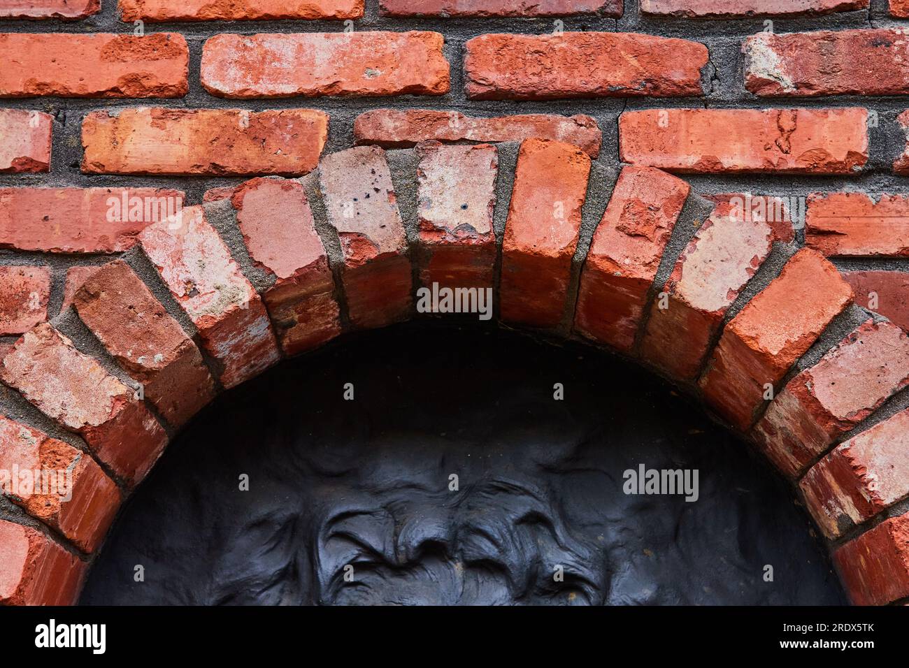 Horizontal red bricks with circular archway on bottom with partial ...