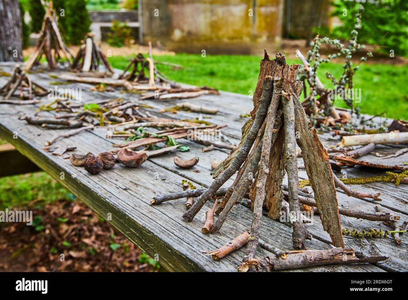 Park background of picnic table covered in small stick teepee piles ...