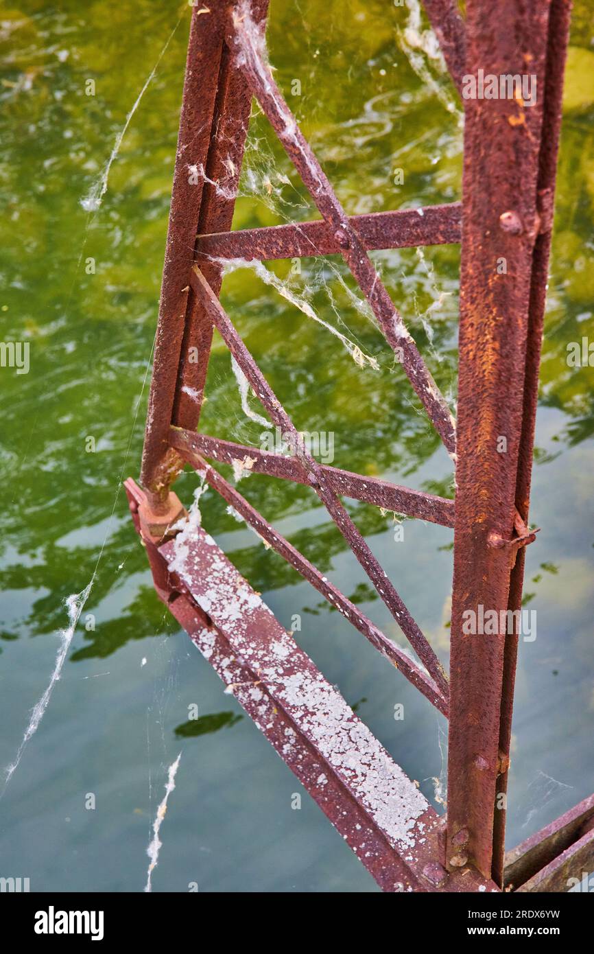 Textured and rusty bridge part with crisscrossing thin metal beams over ...